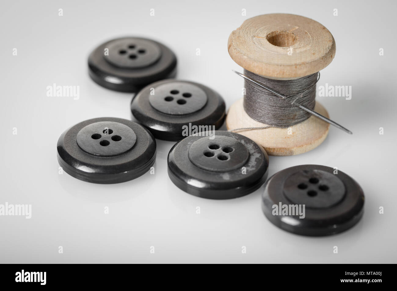 spool of thread and buttons on white background Stock Photo - Alamy