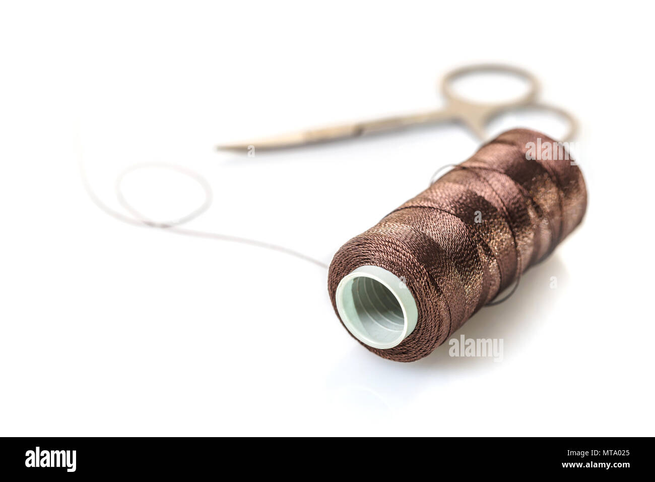 spool of brown threads on a white background Stock Photo - Alamy