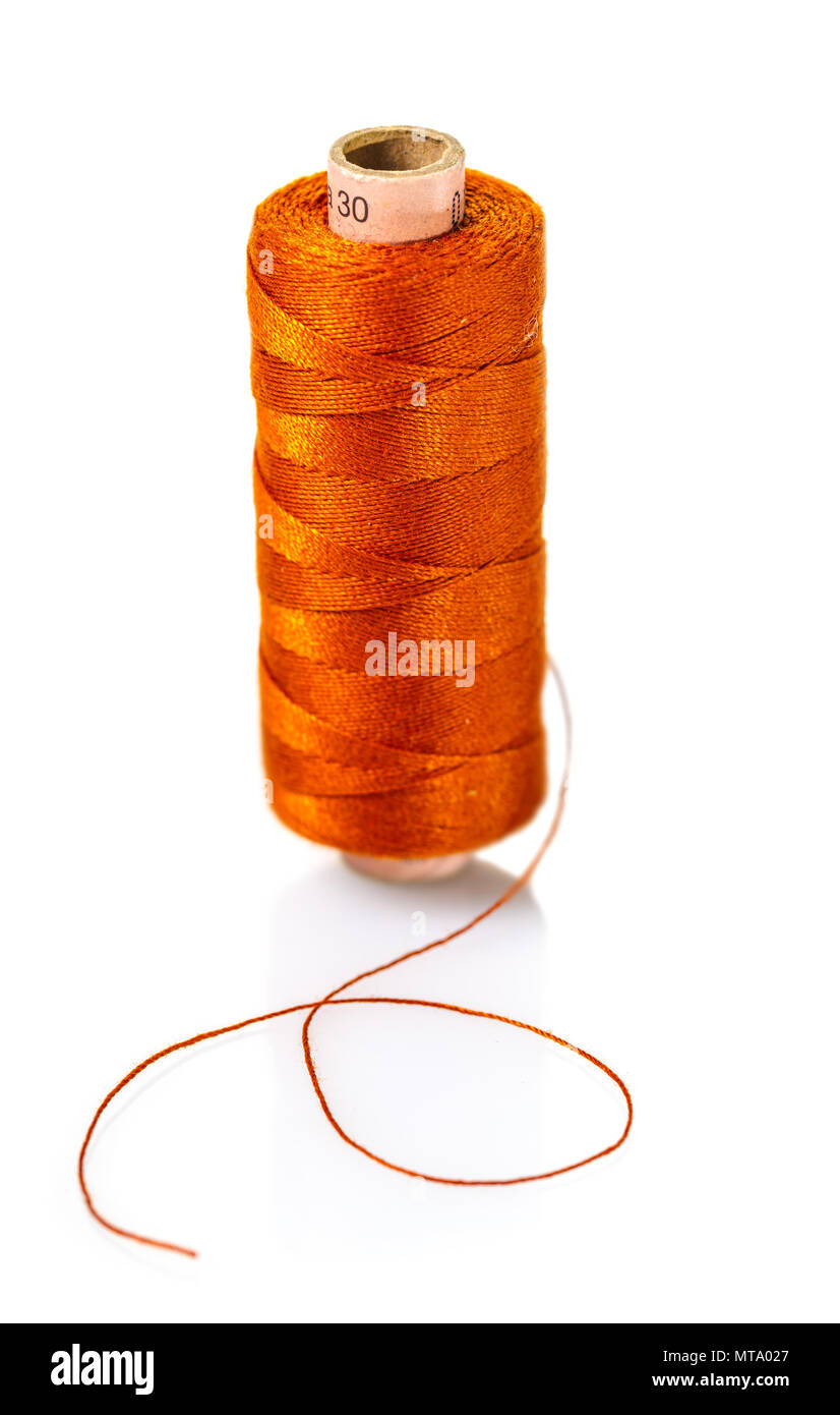 spool of orange threads on a white isolated background Stock Photo - Alamy