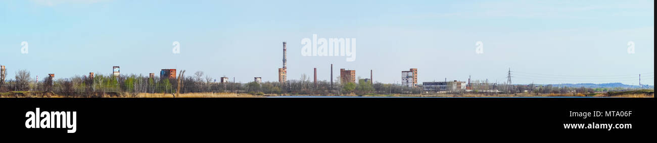 Old Abandoned chemical factory with chimneys on the banks of the river ...