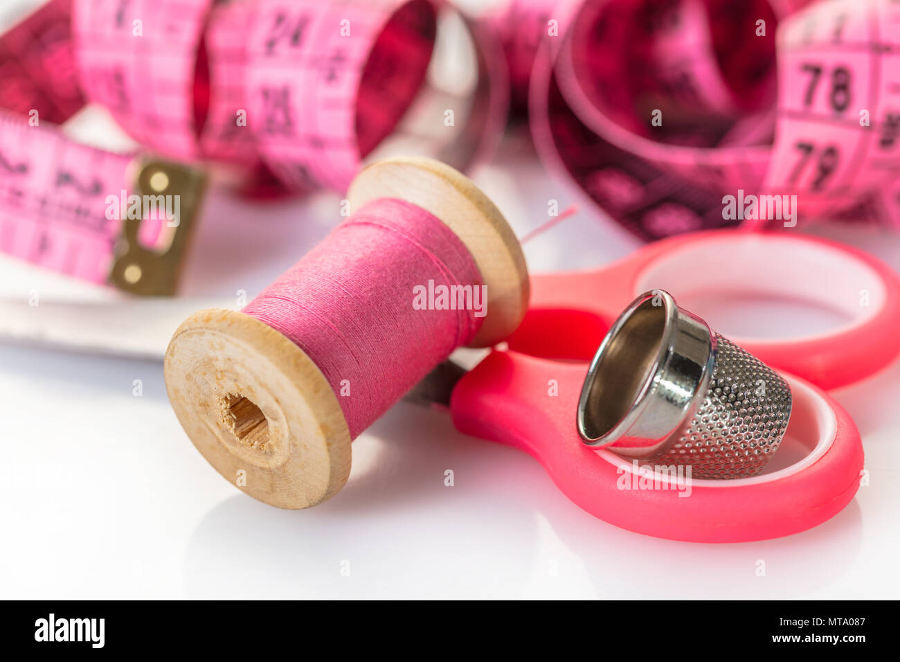 spool of pink thread and meter on white background Stock Photo - Alamy