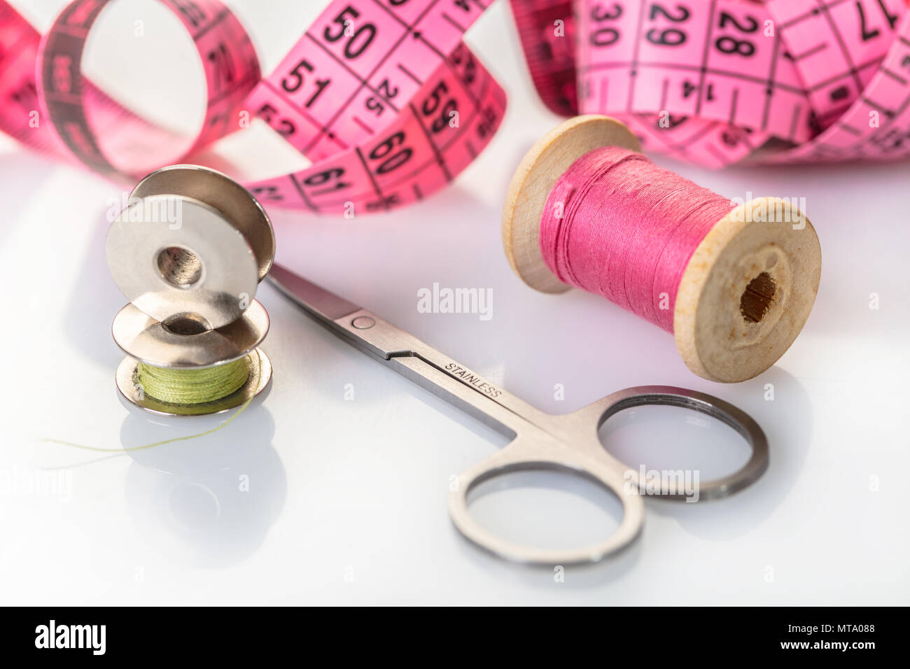 spool of pink thread and meter on white background Stock Photo - Alamy