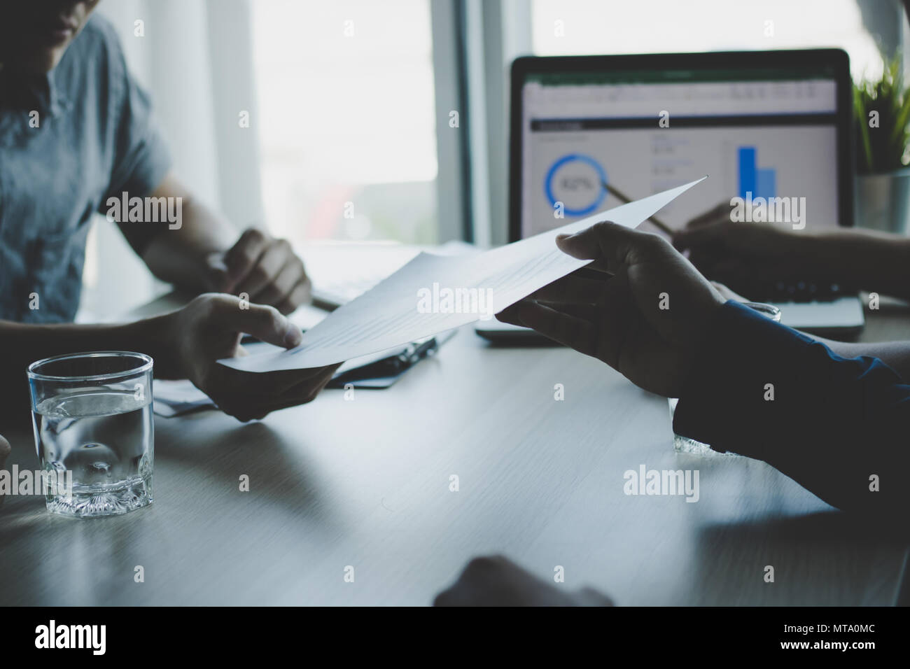 Bussinessman giving businessman giving business graph paper to partner ...