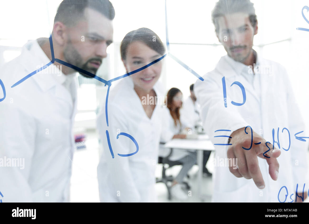 group of laboratory scientists discussing their research in the ...