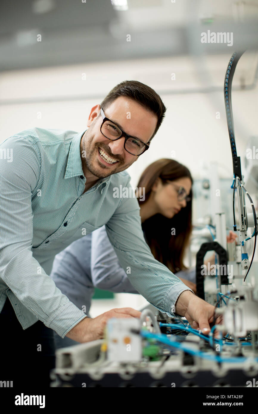Young couple of students working at robotics lab Stock Photo - Alamy