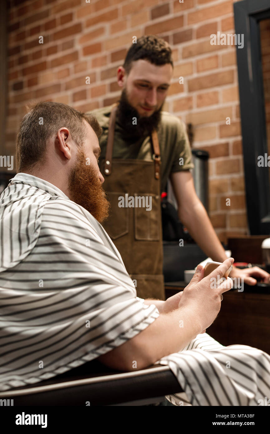 Barber and bearded man in barber shop Stock Photo - Alamy