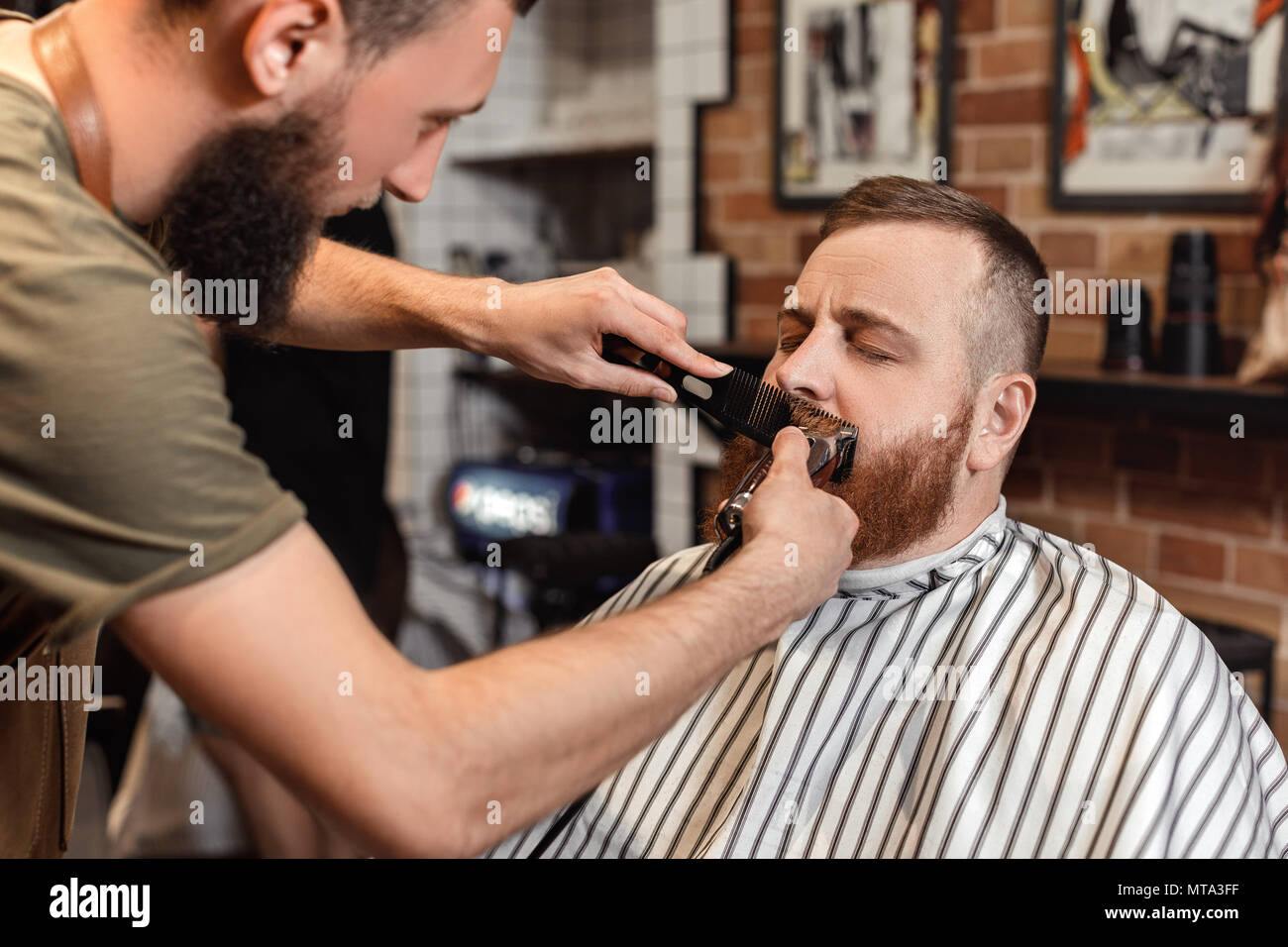 Barber and bearded man in barber shop Stock Photo - Alamy