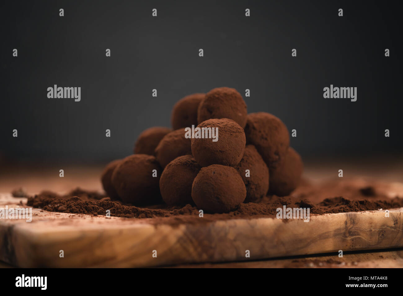 craft chocolate truffles on wooden board with cocoa powder, shallow ...