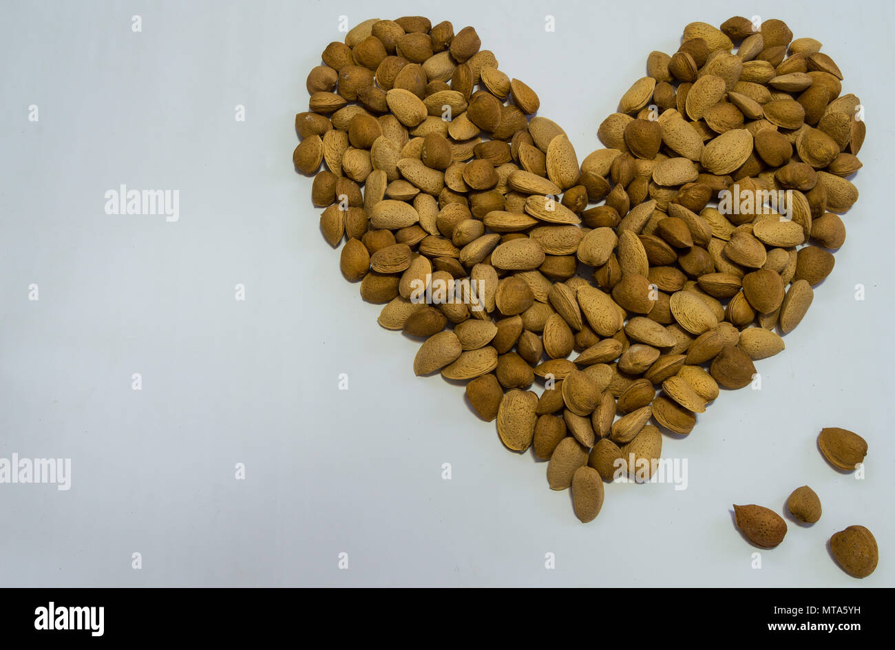 Heart made with almonds with peel isolated on white background. Concept ...