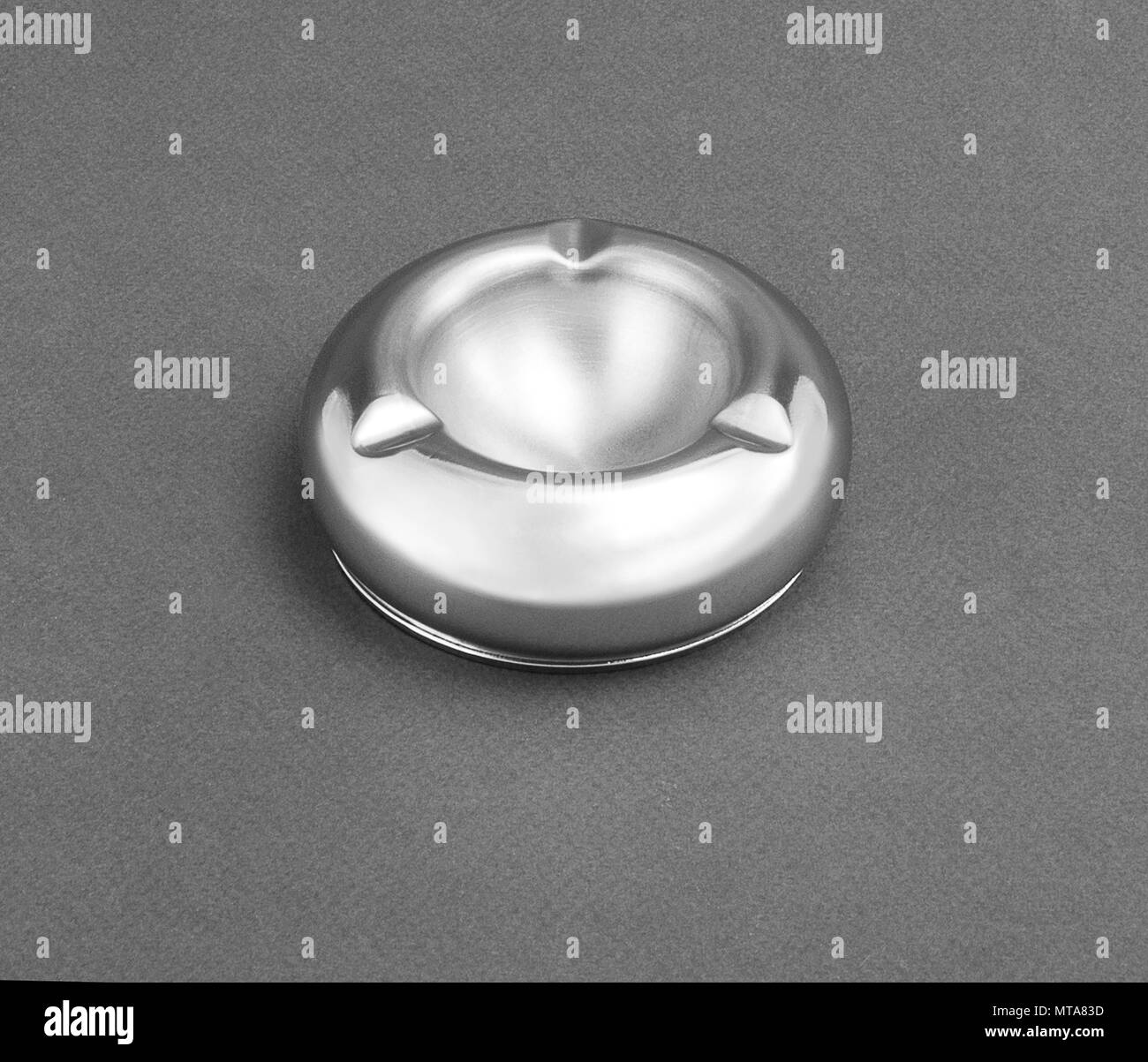 Round metal ashtray on a gray background Stock Photo - Alamy