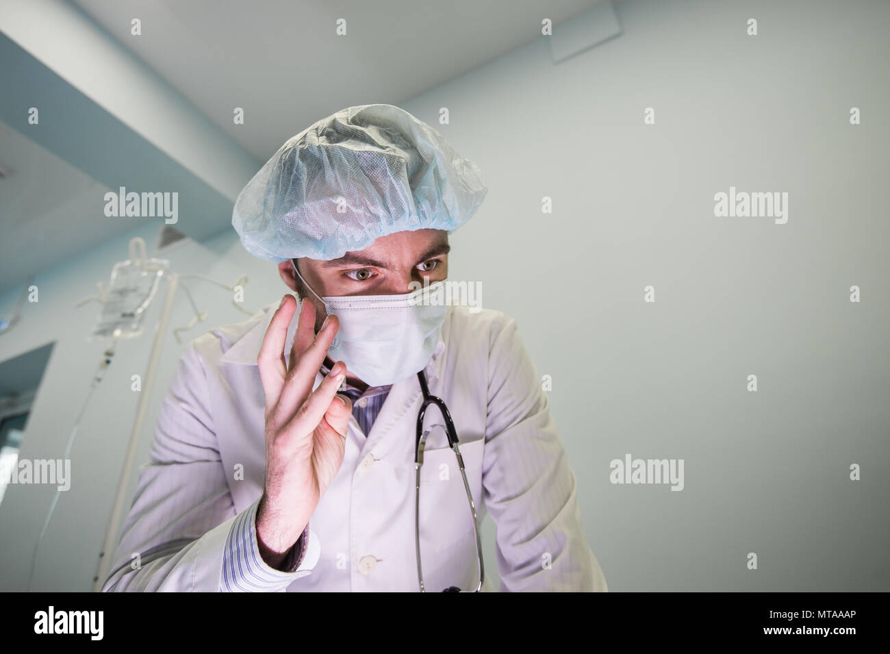 Face of surgeon watching operation from above talking to the patient ...
