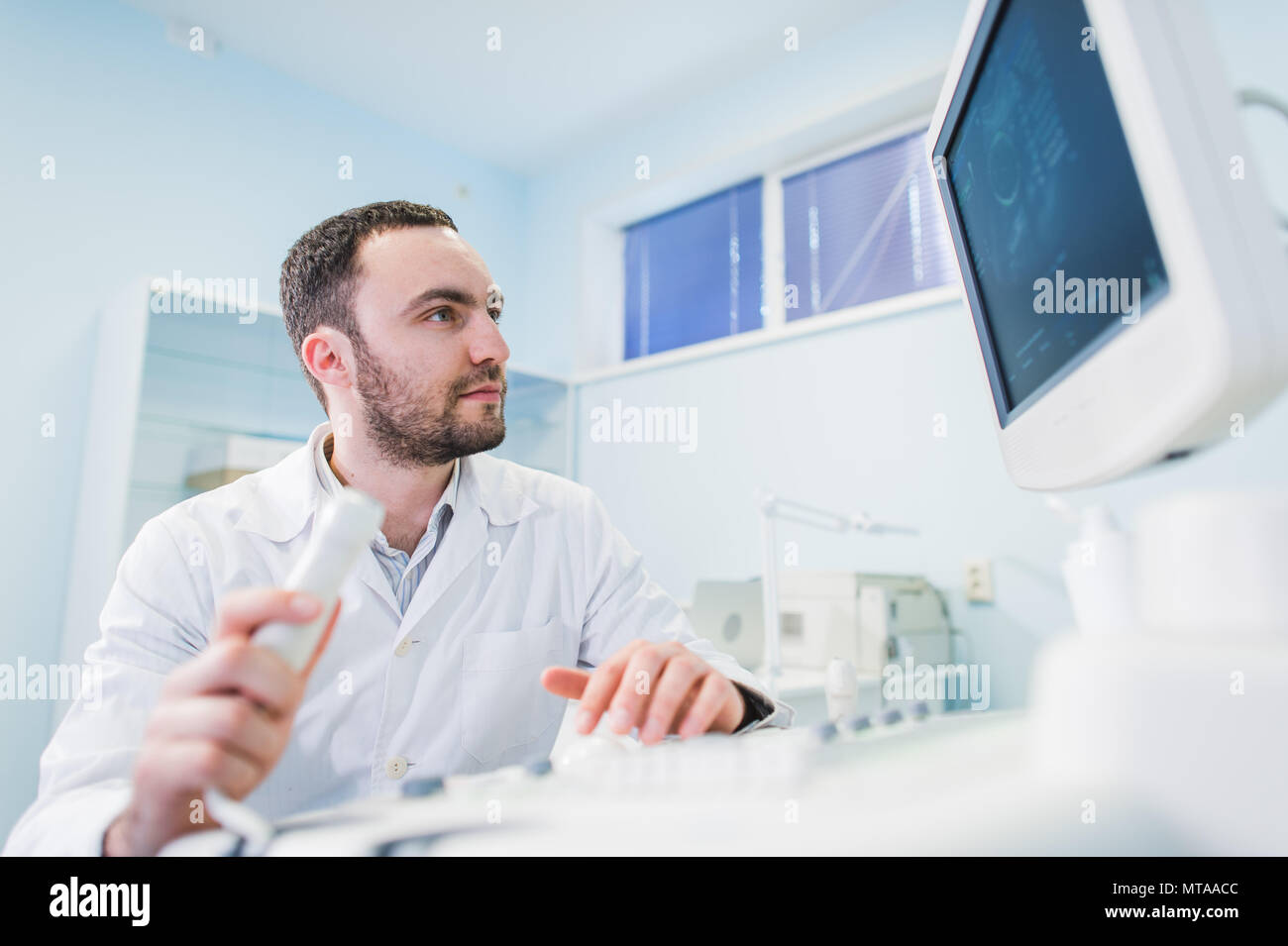 Handsome doctor using ultrasound hi-res stock photography and images ...