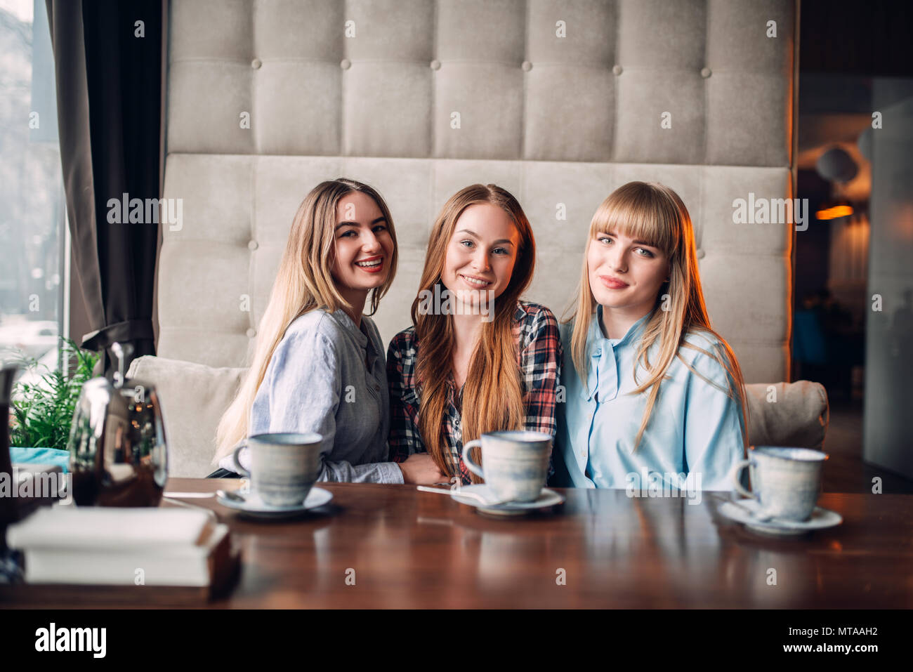 Three attractive girlfriends having lunch in cafe. Female friends ...