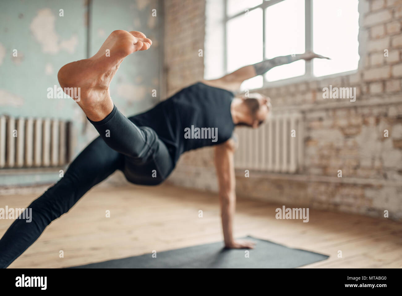 Yoga training on mat in studio with grunge interior. Fit workout ...