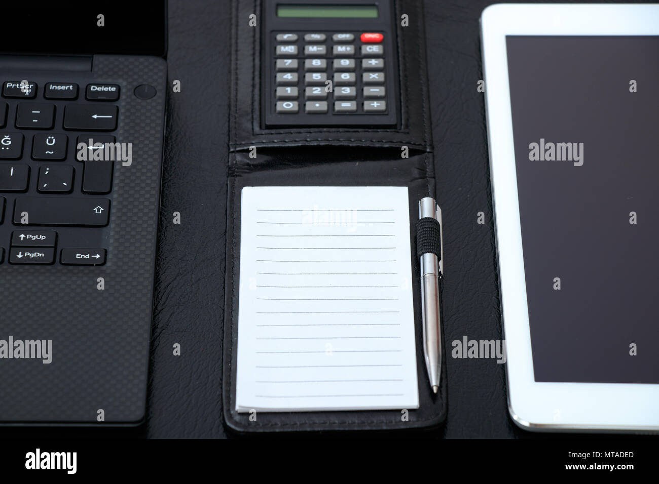 Overhead of office table with notebook, computer keyboard, tablet pc ...