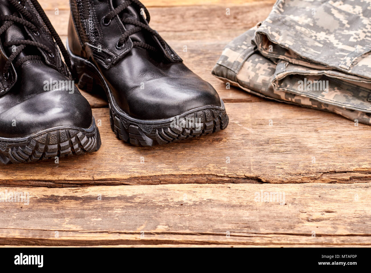 Extreme close up black soldier boots. Military camouflage clothes ...