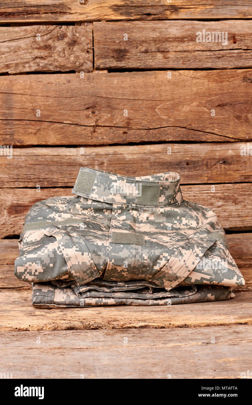 Folded military clothes. Camouflage soldier uniform on wood Stock Photo ...