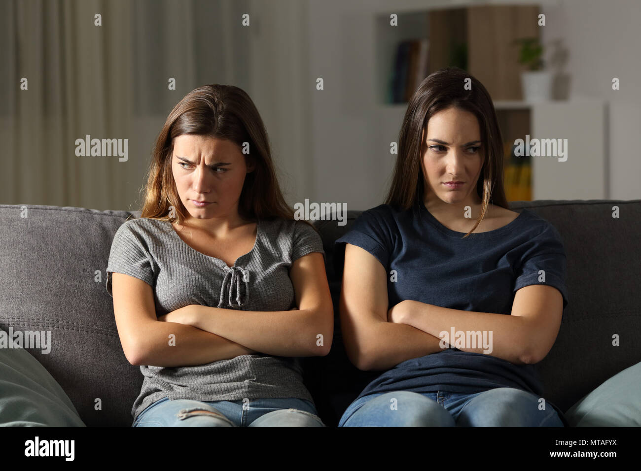 Front view portrait of two anfry friends ignoring each other at home in ...