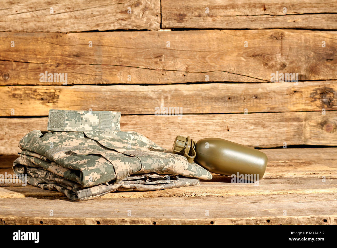 Folded soldier uniform and bottle. Old wood background Stock Photo - Alamy