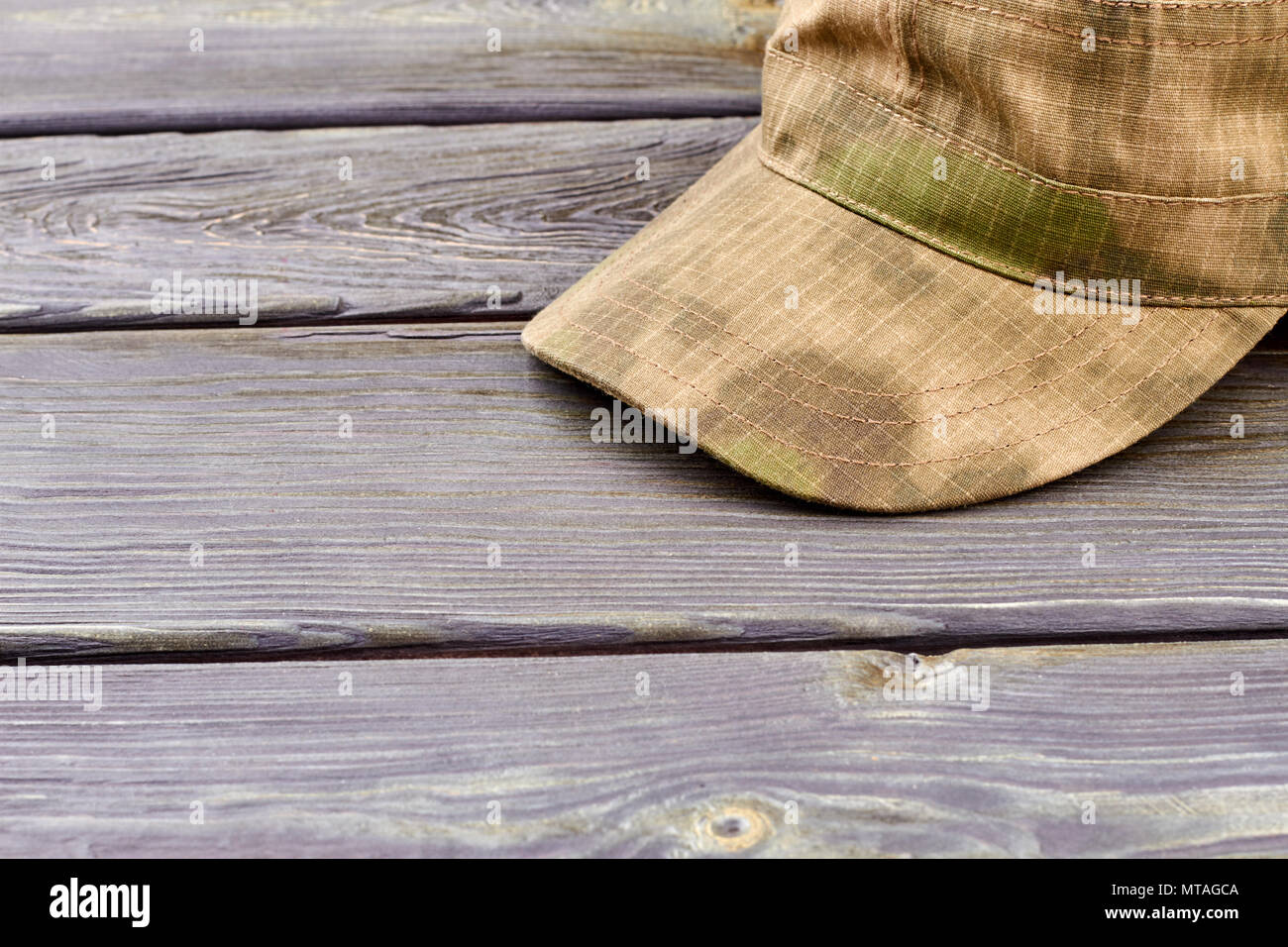 Military cap close up. Wooden desk surface background Stock Photo - Alamy