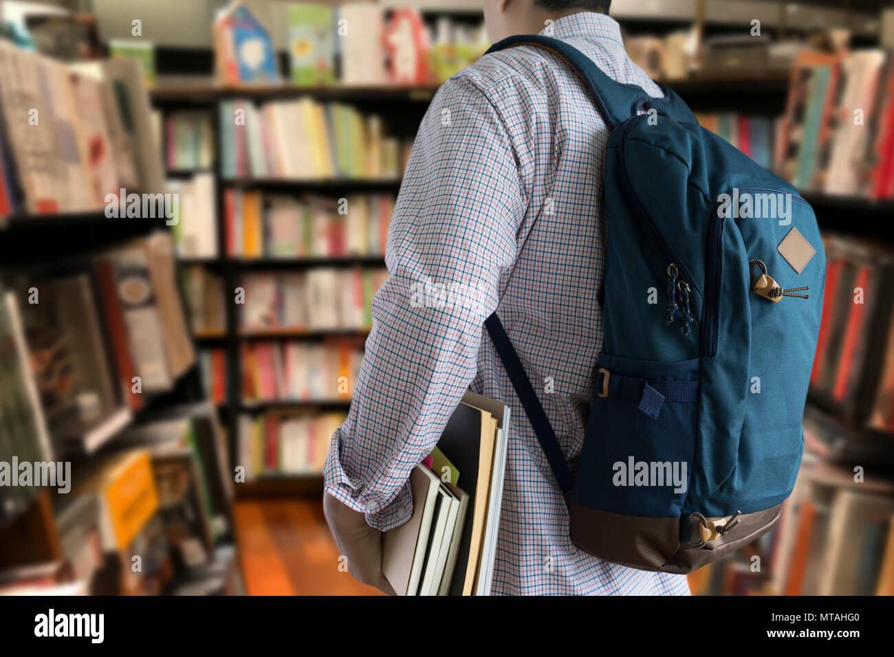 Happy Student with backpack go to holding books library bookshelves ...