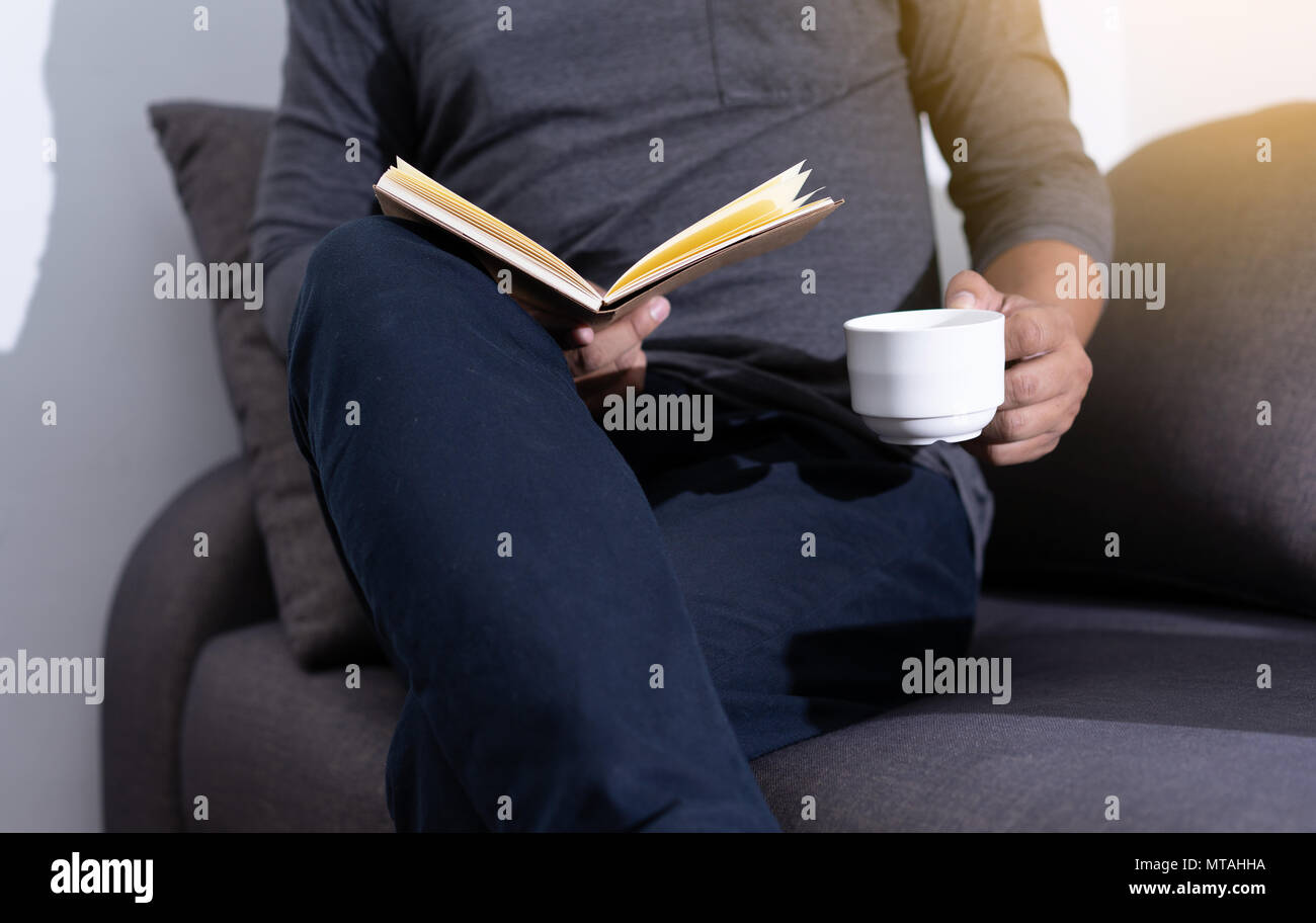man reading a book and holding cup of coffee Sit Read Knowledge Stock ...