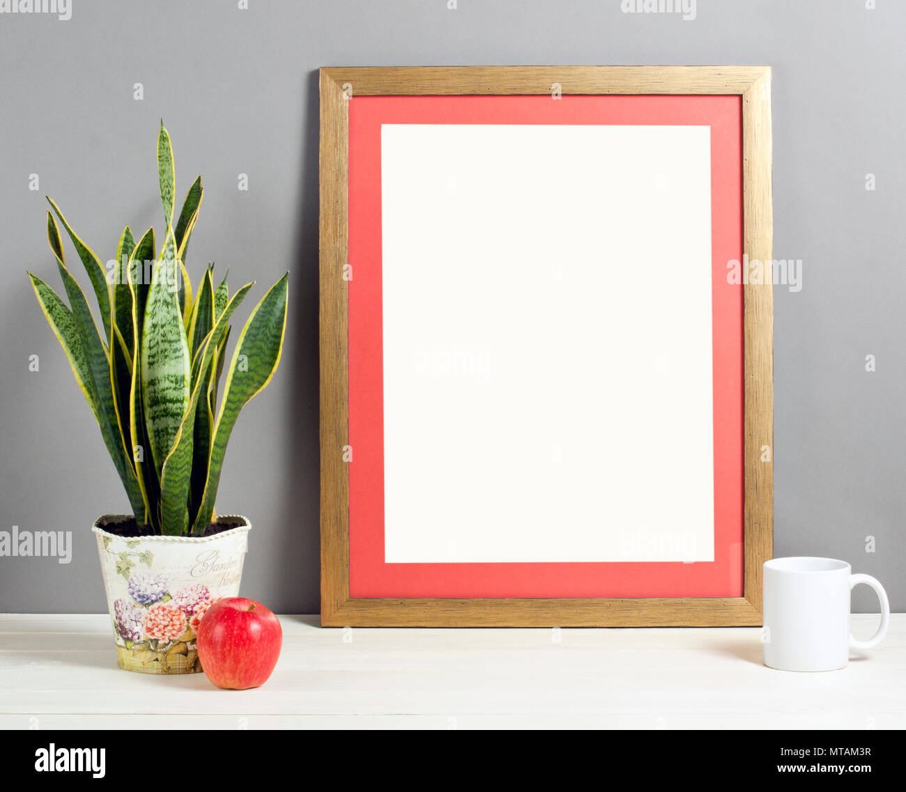 Brown frame mockup with plant pot, mug and apple on wooden shelf. Empty ...