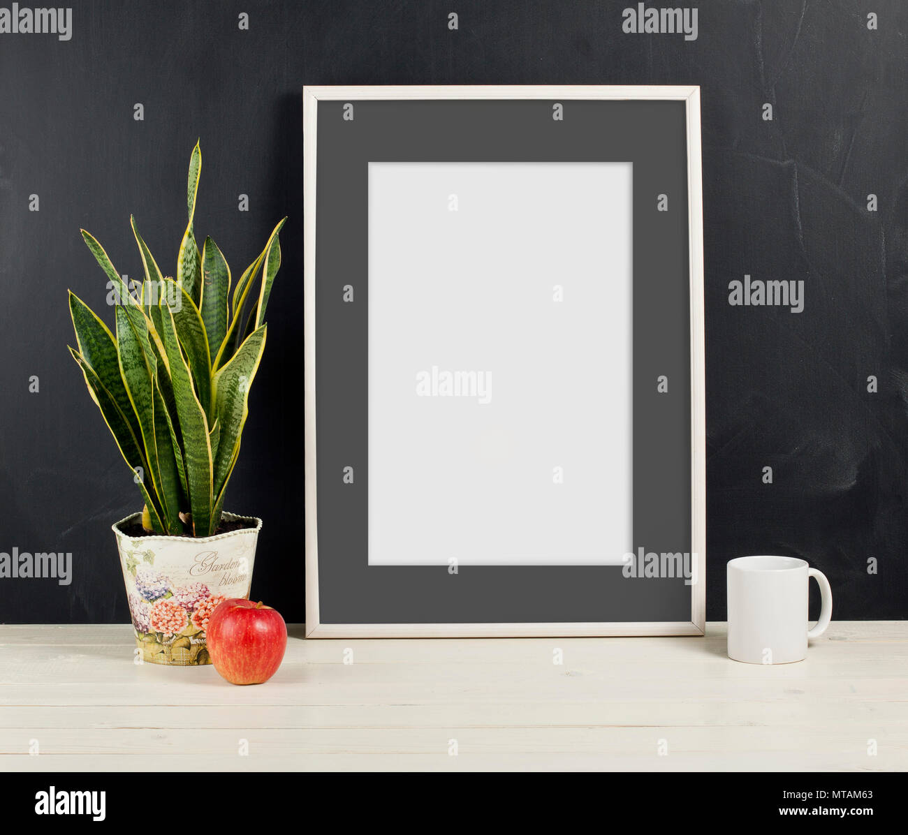 Frame mockup with plant pot, apple and mug. Empty frame mock up for ...