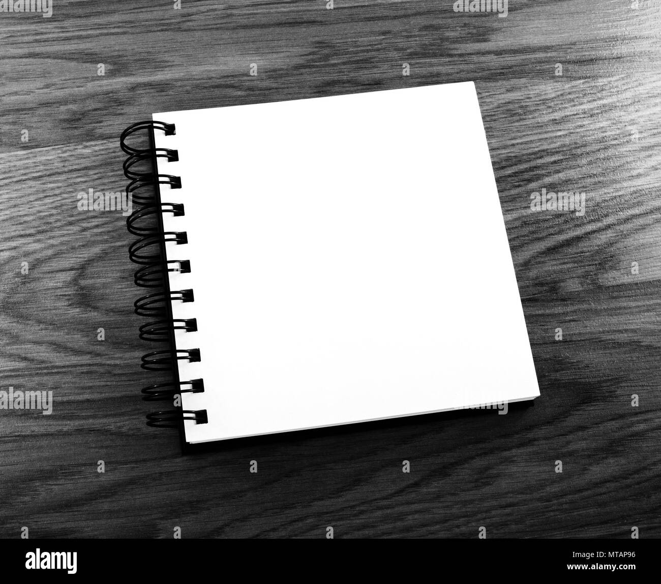 Notepad with a spiral binding on a wooden background Stock Photo - Alamy