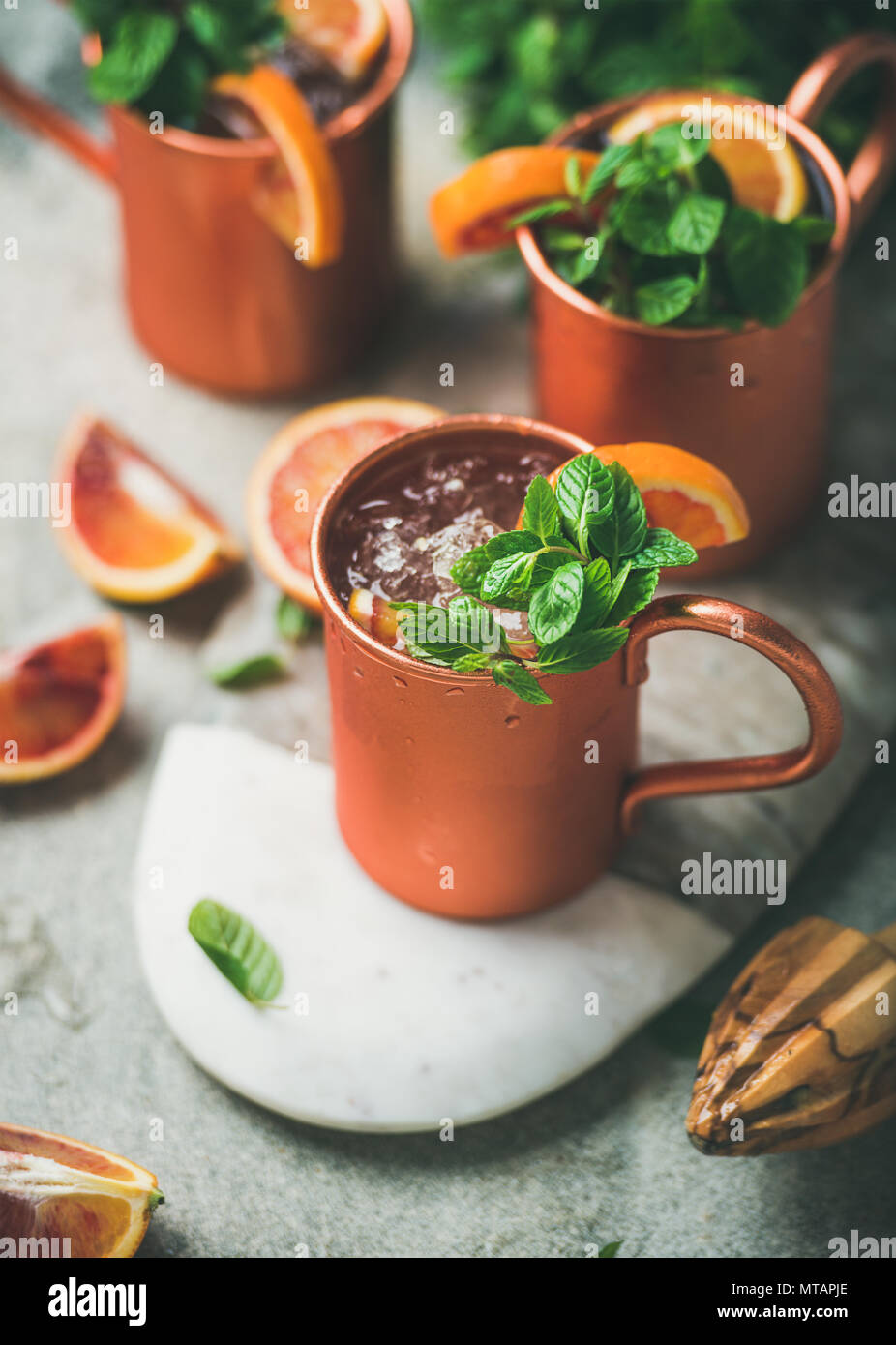 Blood orange Moscow mule alcohol cocktails in mugs on board Stock Photo ...