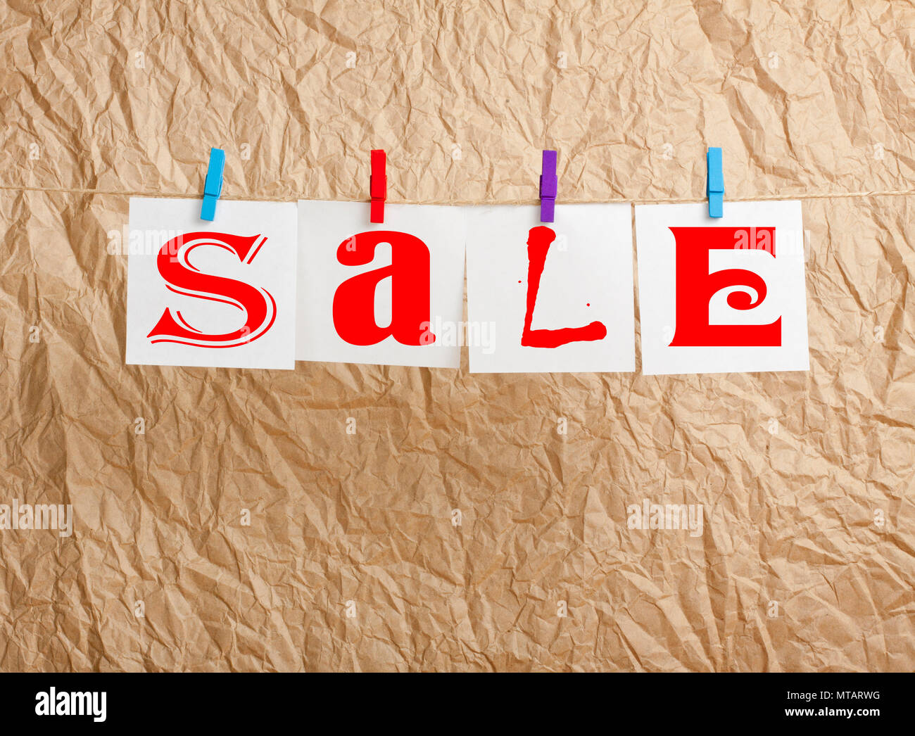 Sale paper label hanging on craft paper background Stock Photo - Alamy