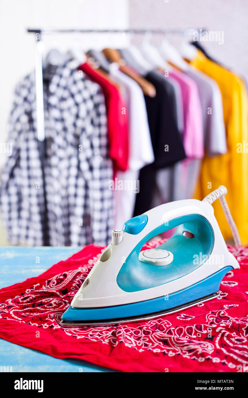 Iron on ironing board on home interior background Stock Photo - Alamy