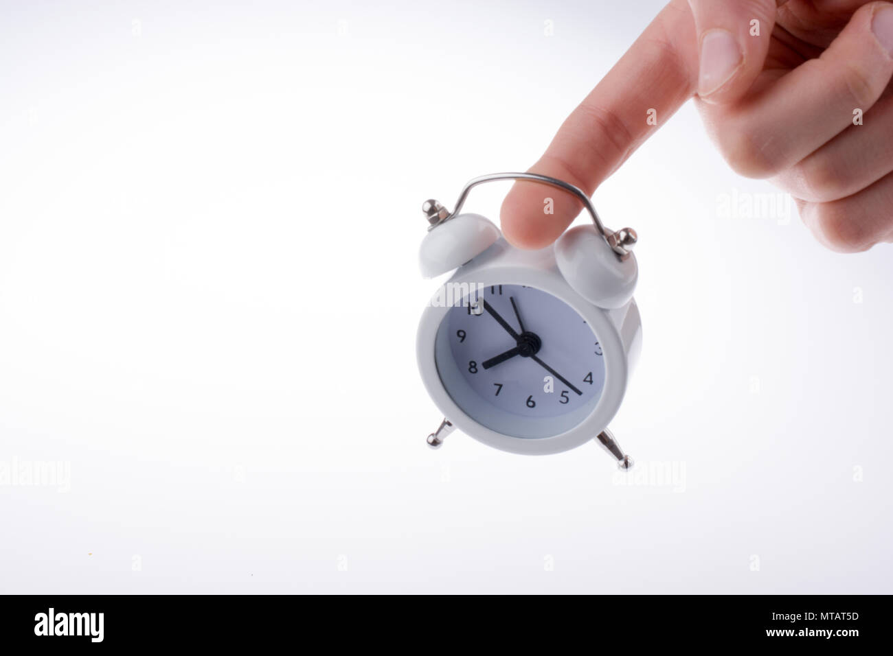 Alarm clock in hand on a white background Stock Photo - Alamy