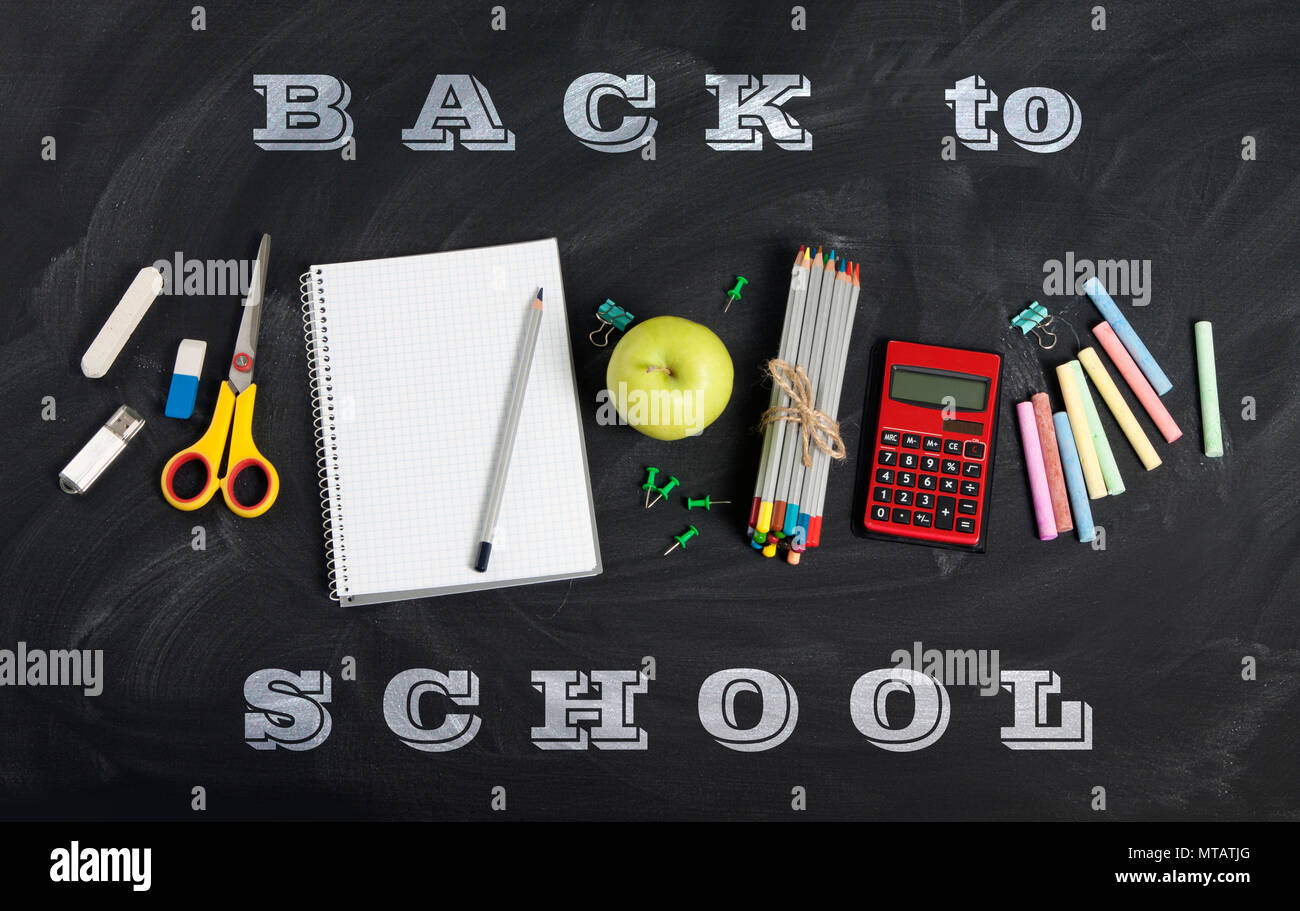 "Back to school" handwritten with school supplies on a black background ...