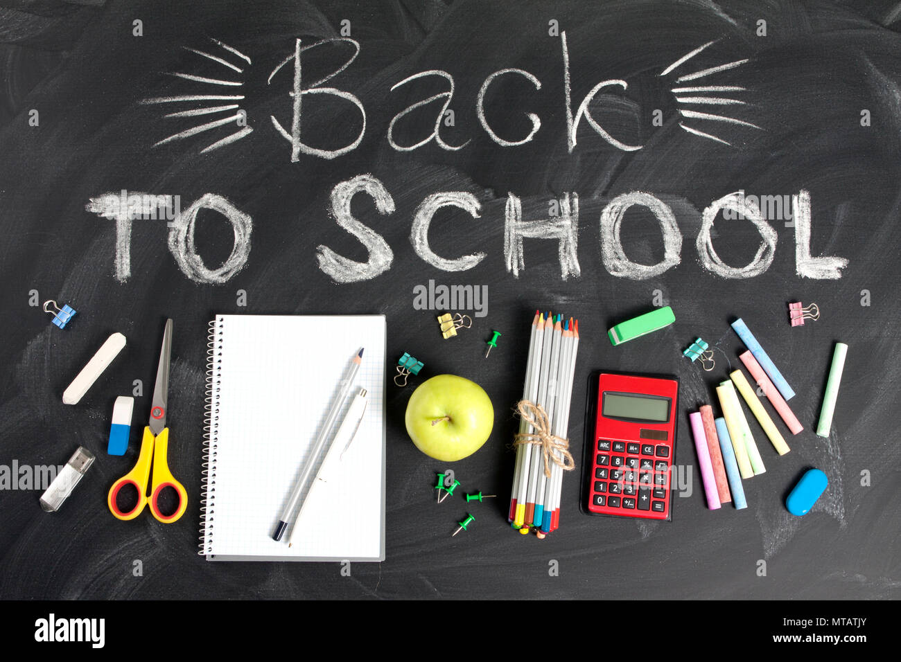"Back to school" handwritten with school supplies on a black background ...