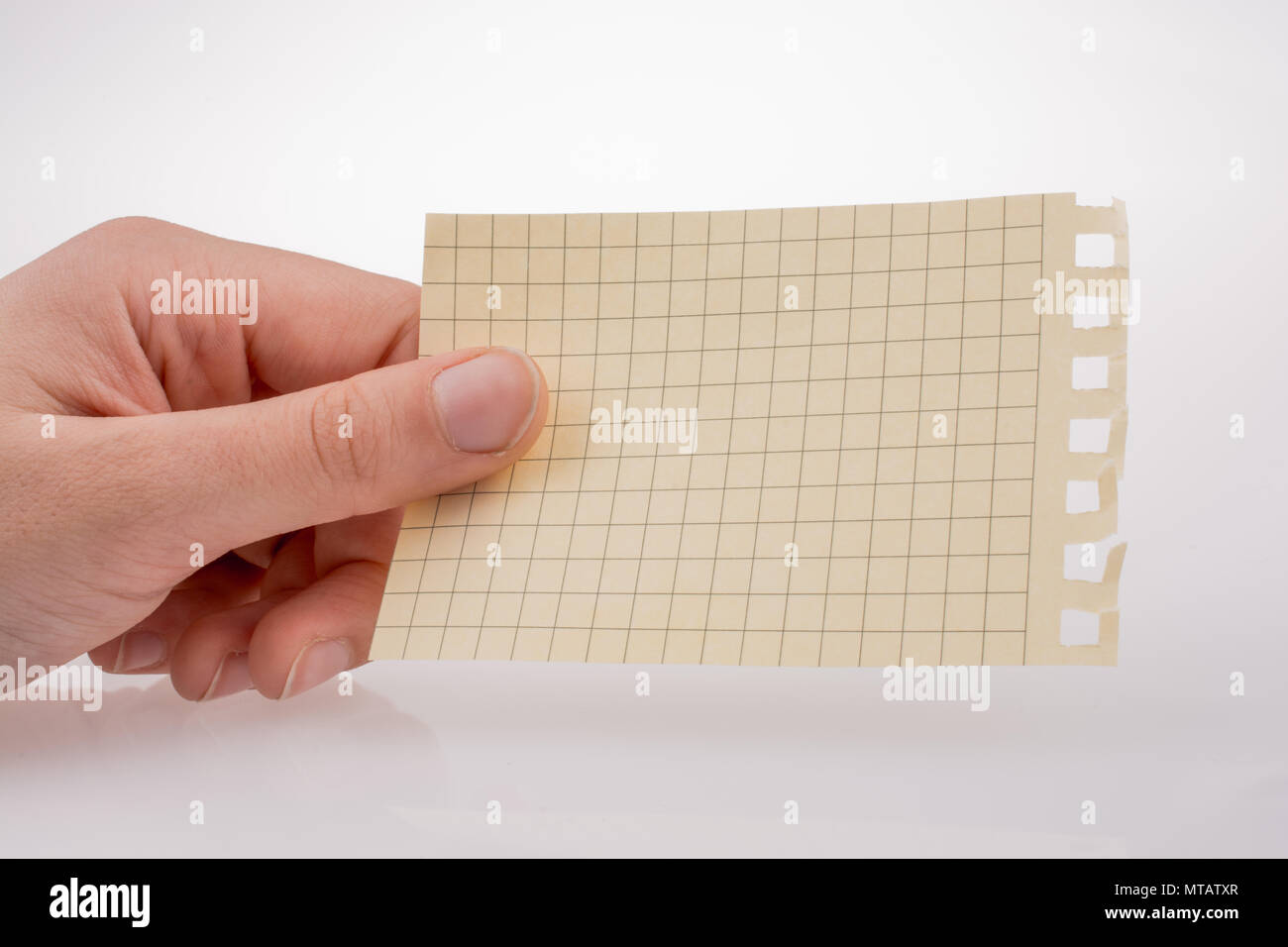 Hand holding a piece of checked paper on a white background Stock Photo ...