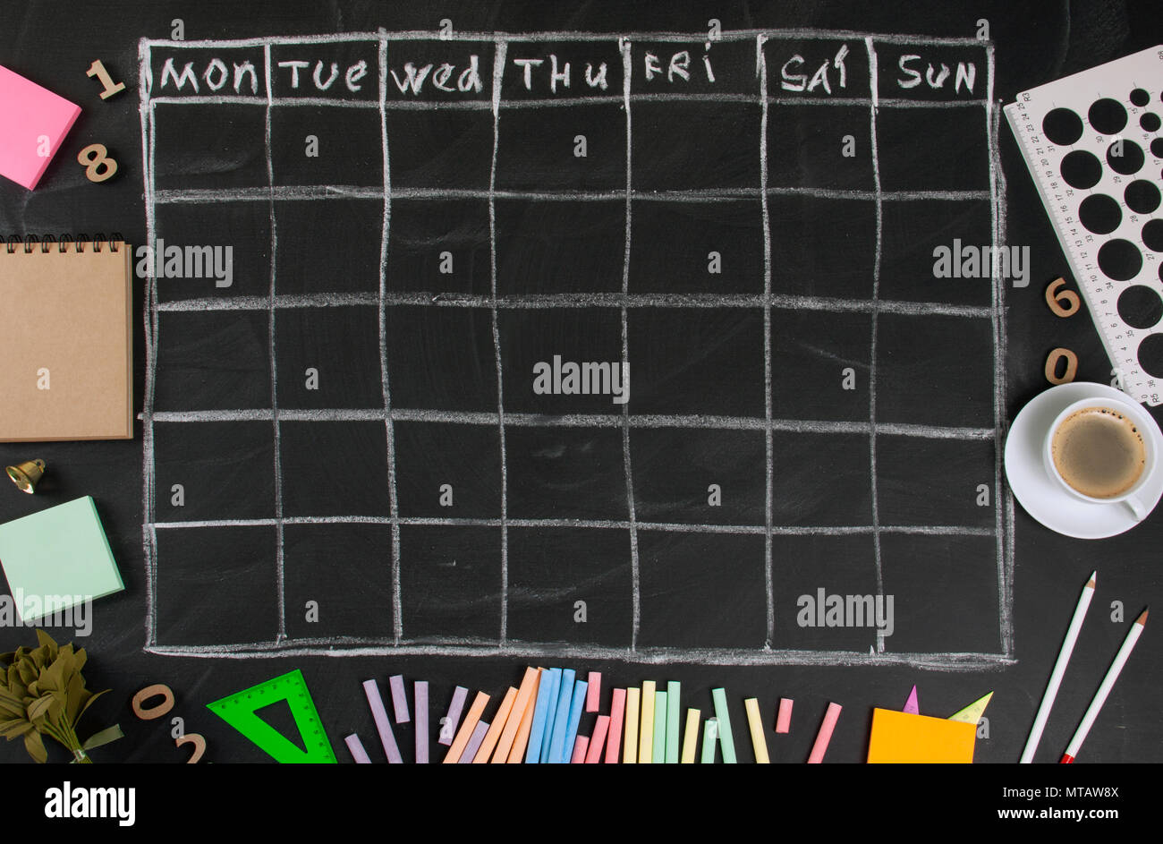 Grid timetable schedule with stationery on black chalkboard background ...