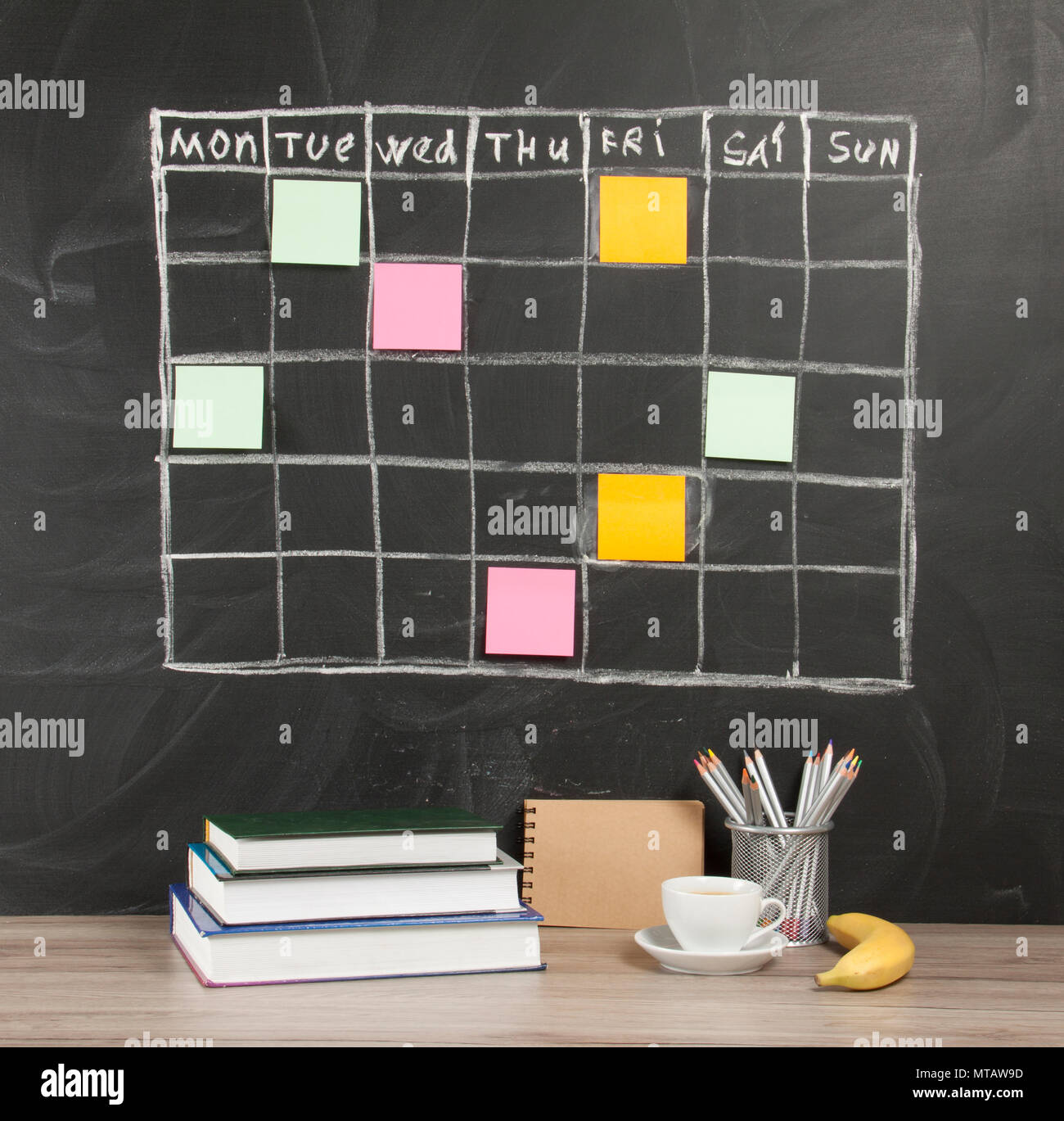 Grid timetable schedule with note paper on black chalkboard background ...