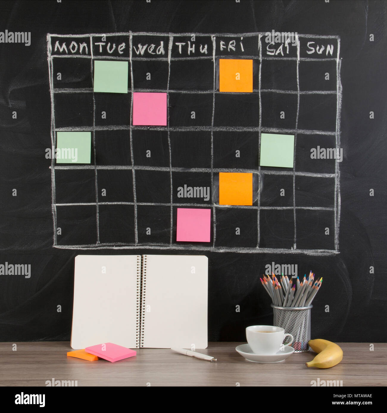Grid timetable schedule with note paper on black chalkboard background ...