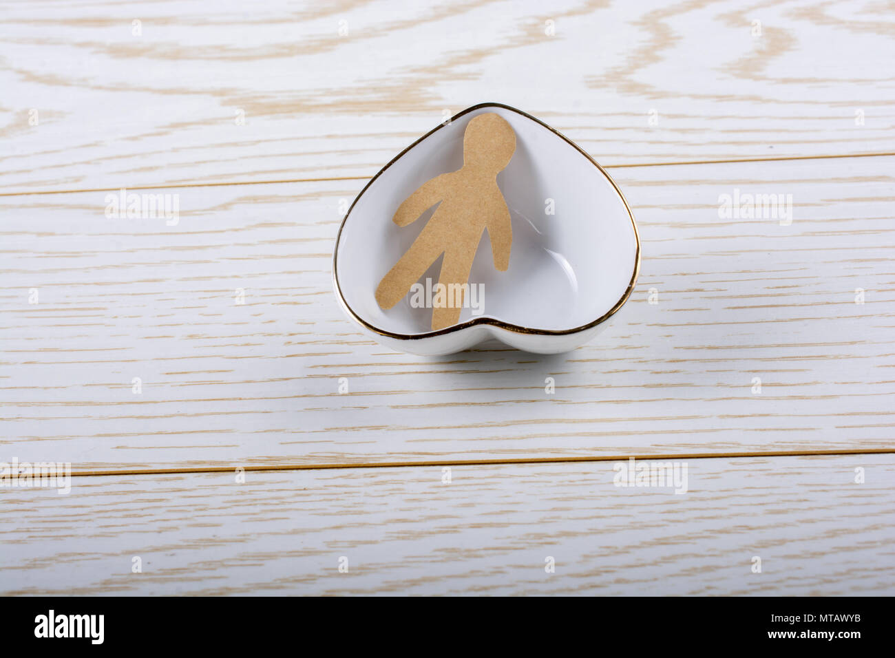 Man shape cut out of paper in hand in the view Stock Photo - Alamy