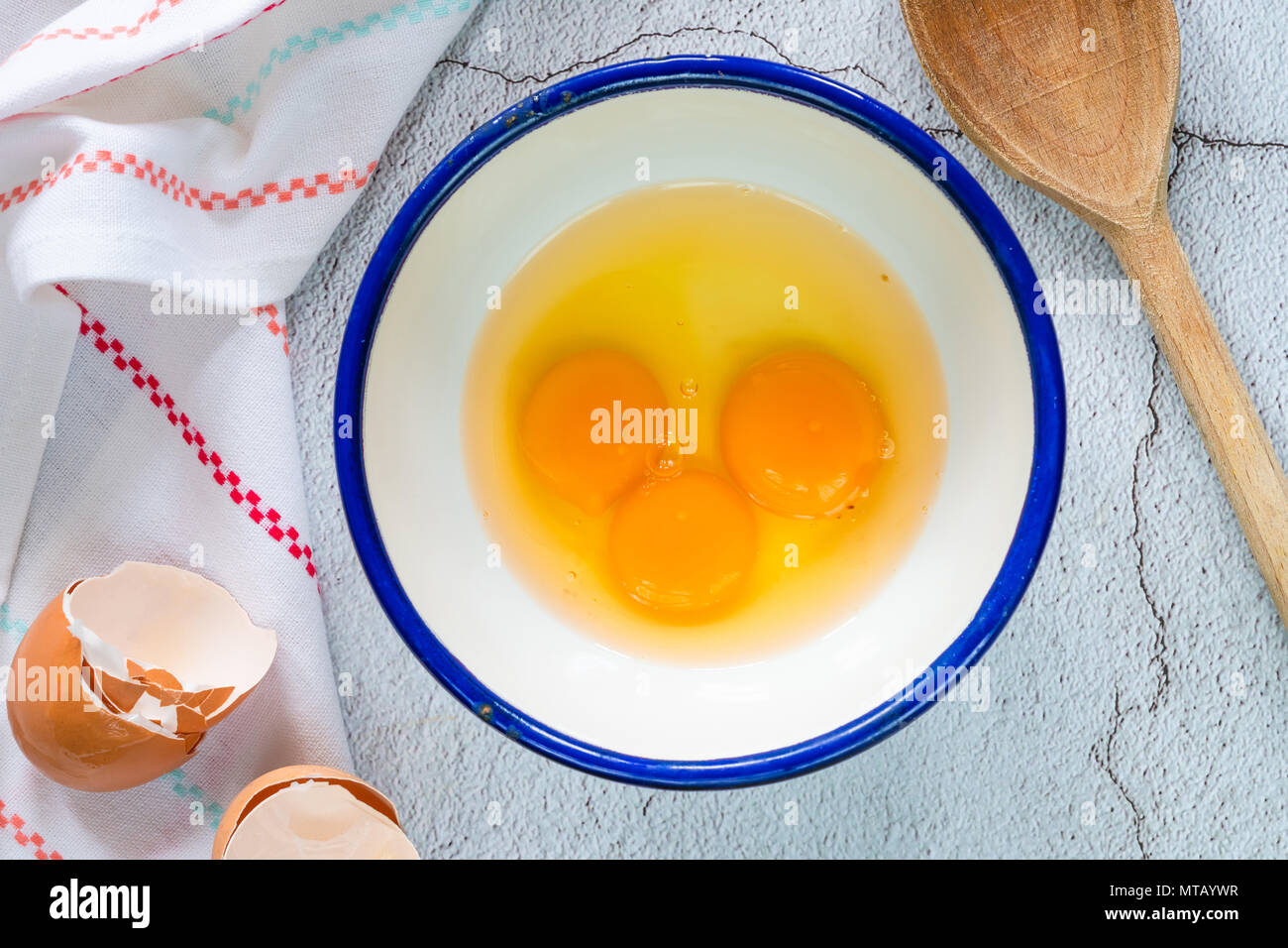Three egg yolks in a bowl - top view Stock Photo - Alamy