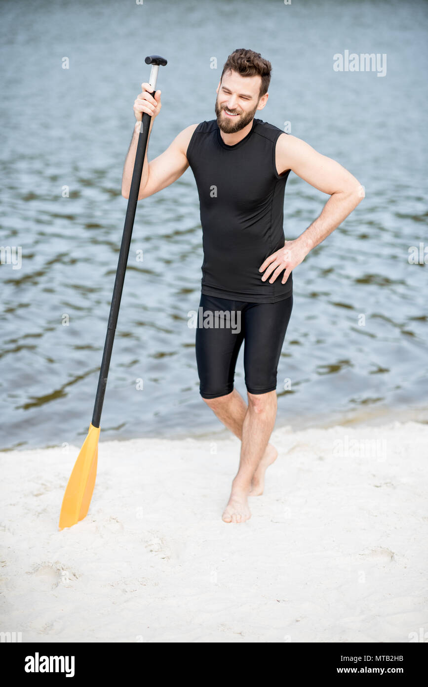 Man with oar on the beach Stock Photo - Alamy