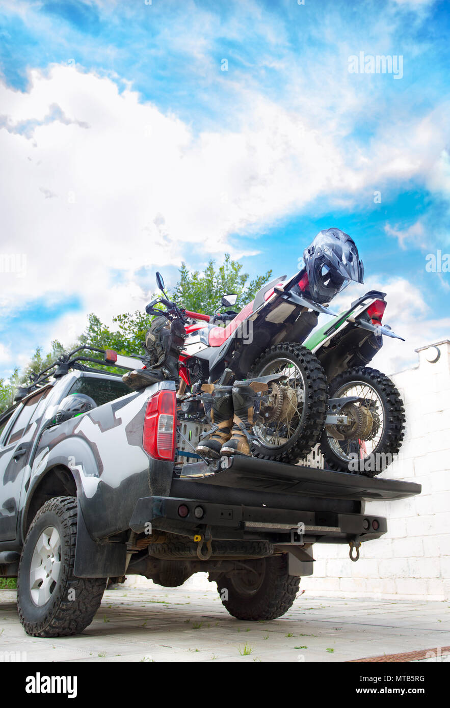 Two dirt bike motorcycles on the back of the camo truck with saf Stock ...