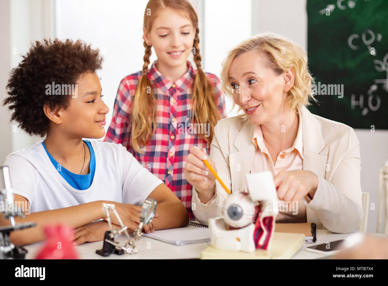 Joyful positive teacher looking at her student Stock Photo - Alamy