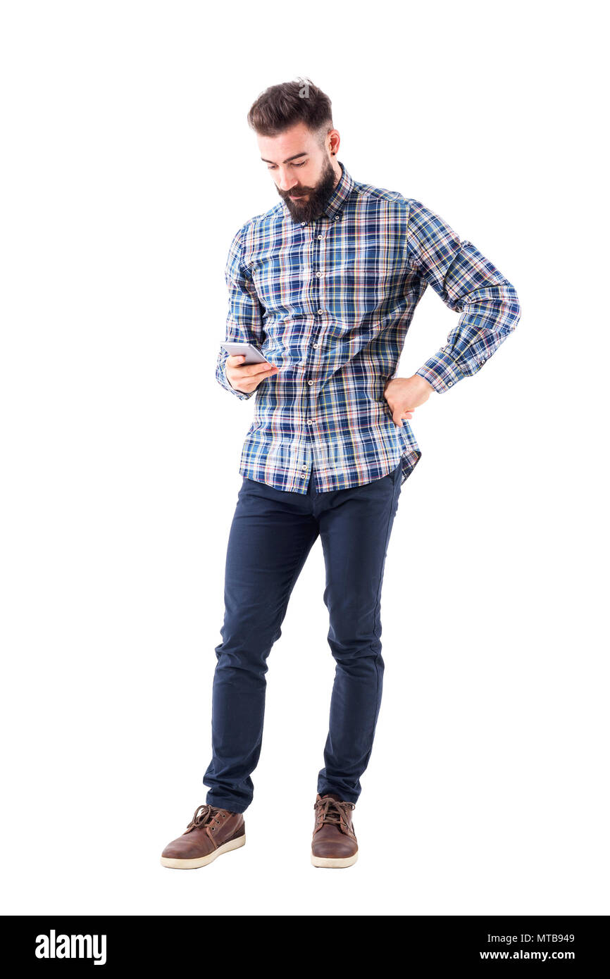 Bearded young Caucasian adult man typing message on mobile phone. Full ...