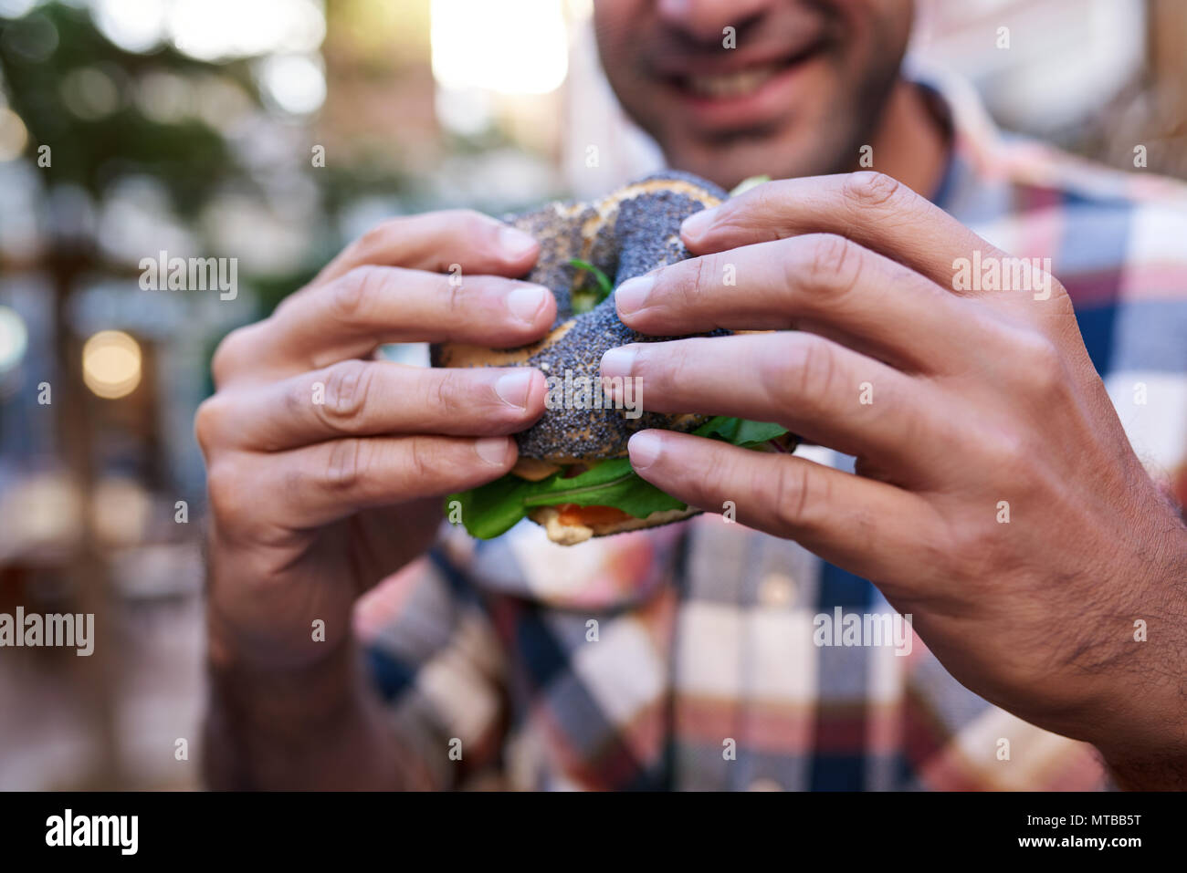 Closeup of a hungry young man smiling and about to take a bite of his ...