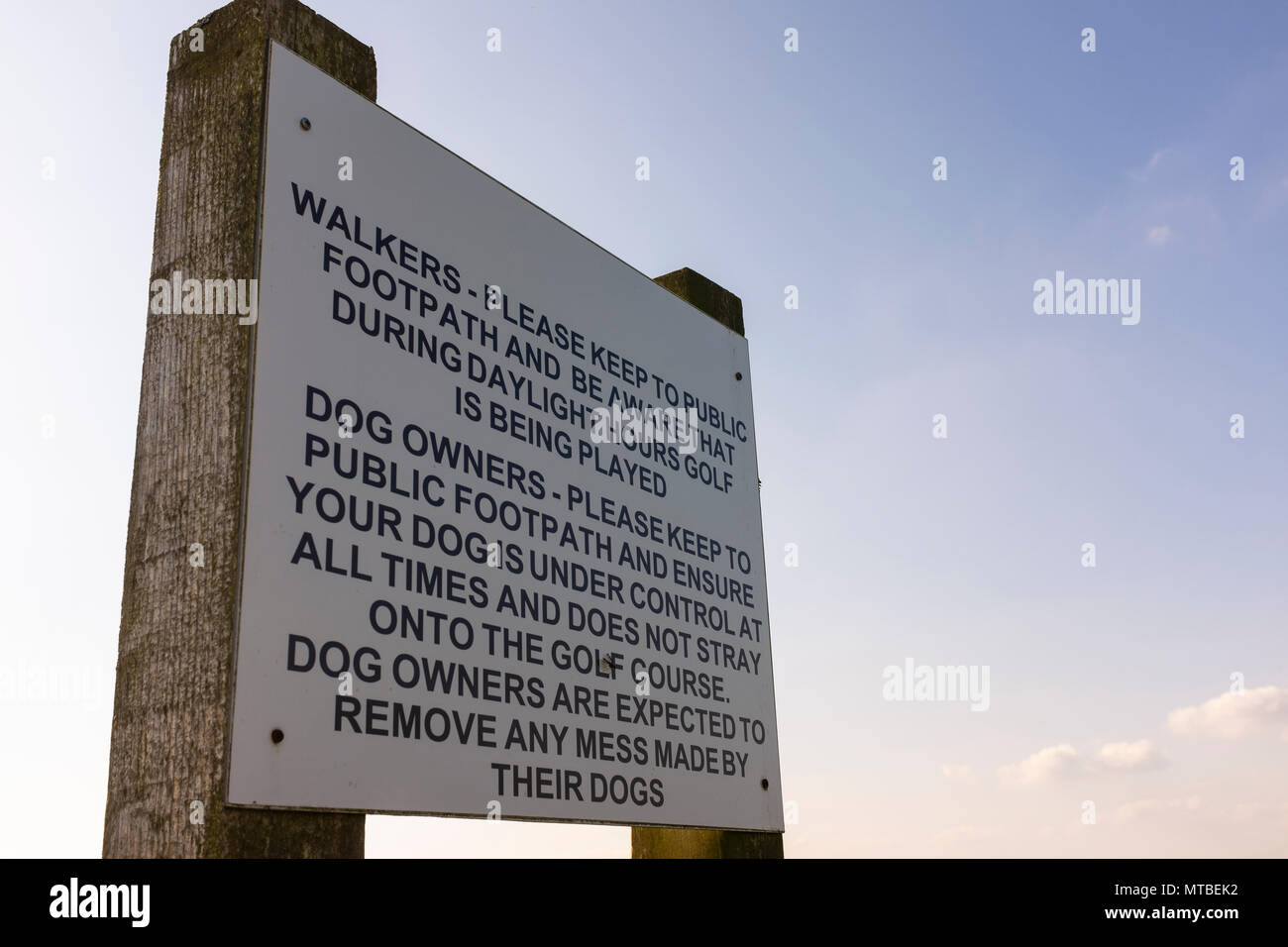 Sign explaining to walkers to keep to the path over a golf course and ...