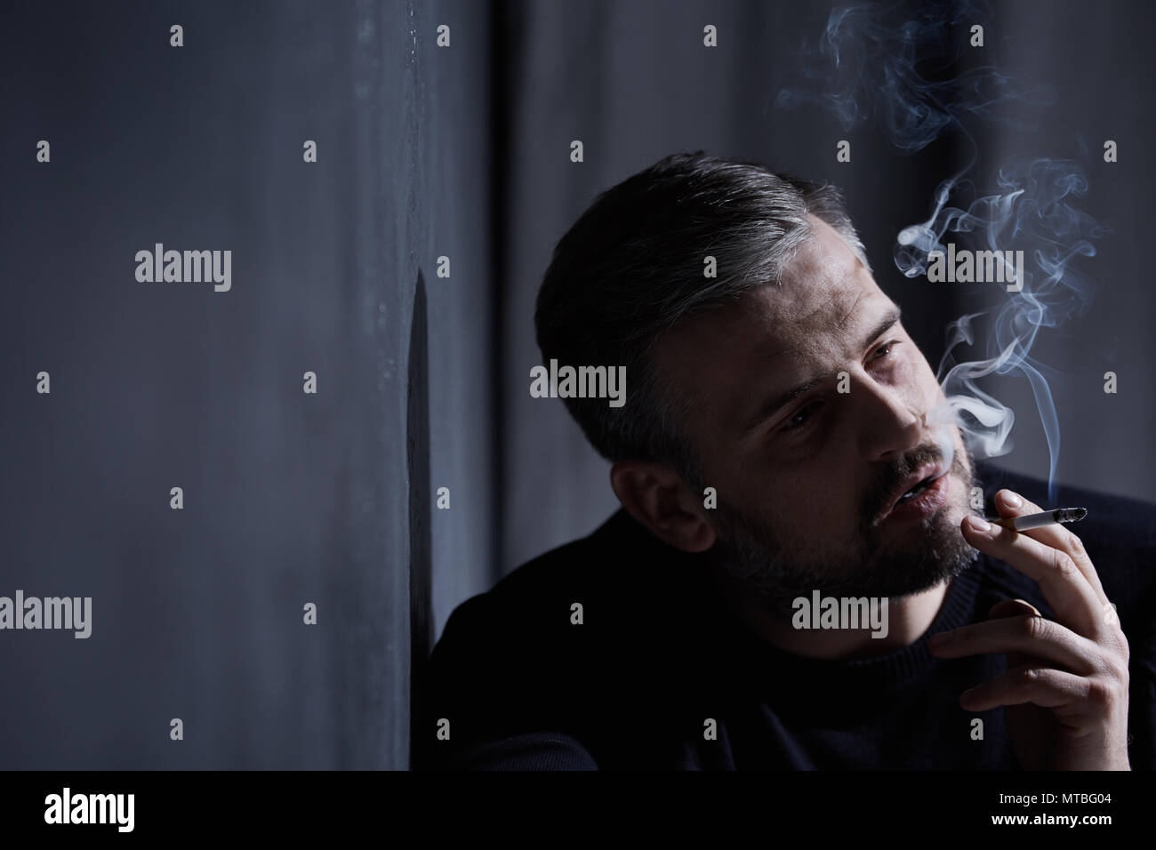 Man with depression inhaling cigarette smoke Stock Photo - Alamy