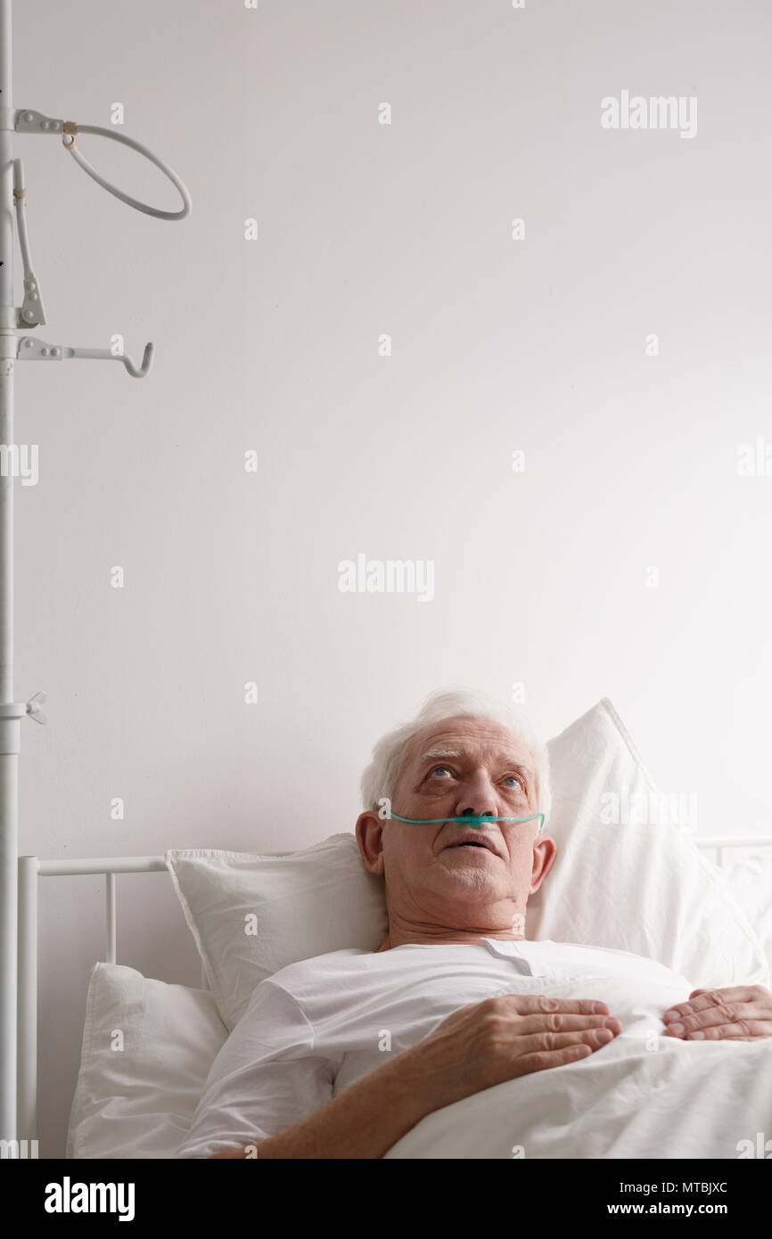 Worried elderly male patient thinking while staring at hospital ceiling ...