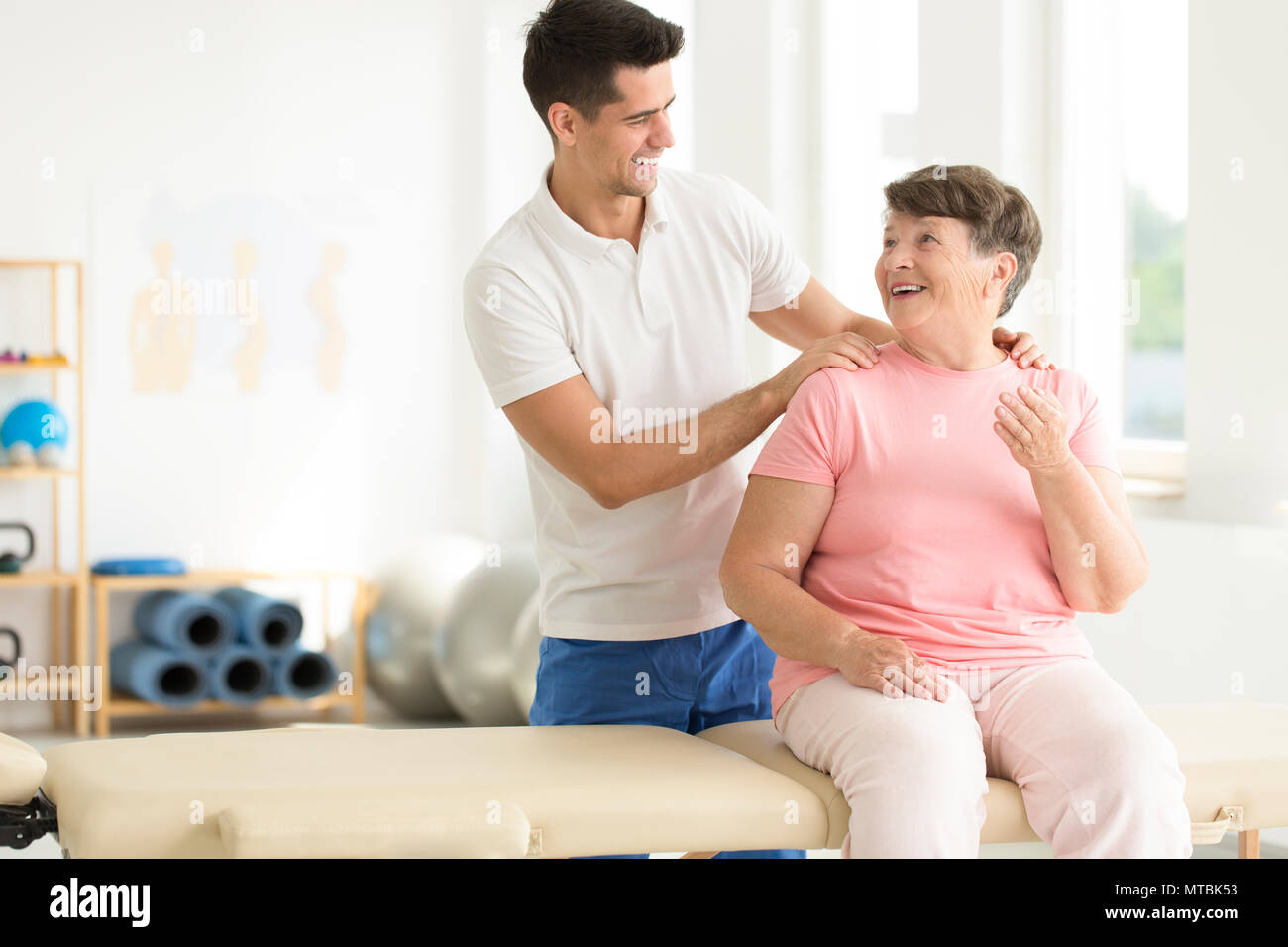 Physiotherapist performing a rehabilitation session with his senior ...
